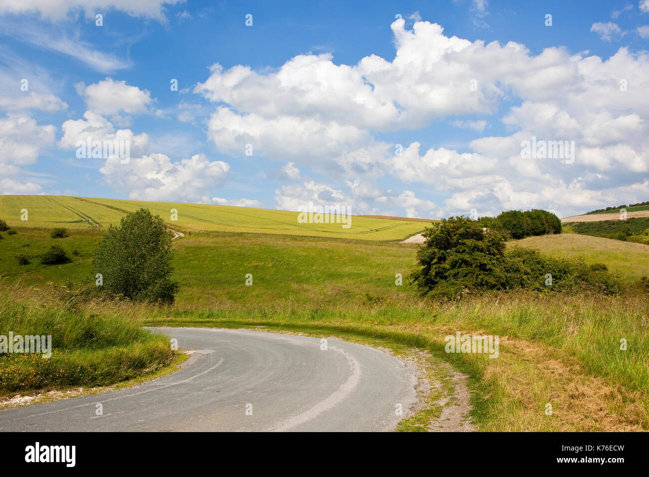 a curved country road going into a scenic valley with hills and ...