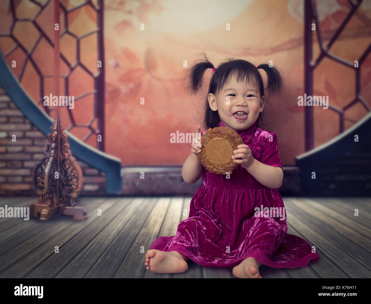 Baby girl eating Chinese moon cake Stock Photo - Alamy