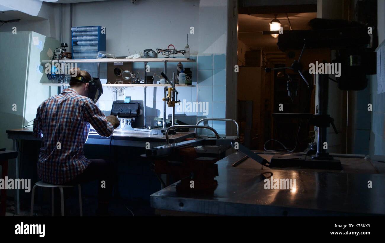 Back view of professional welder man with torch and protective mask ...