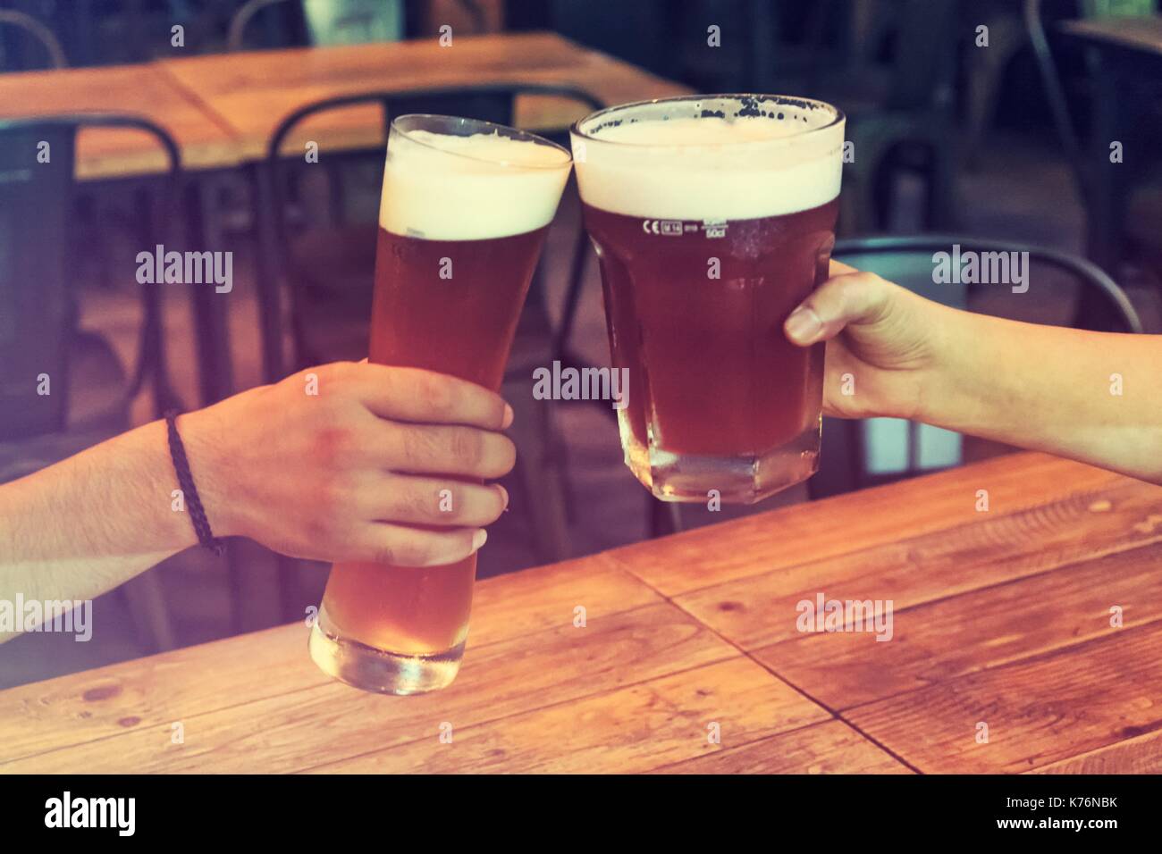 Two hands holding and clinking with beer glasses in the pub Stock Photo ...