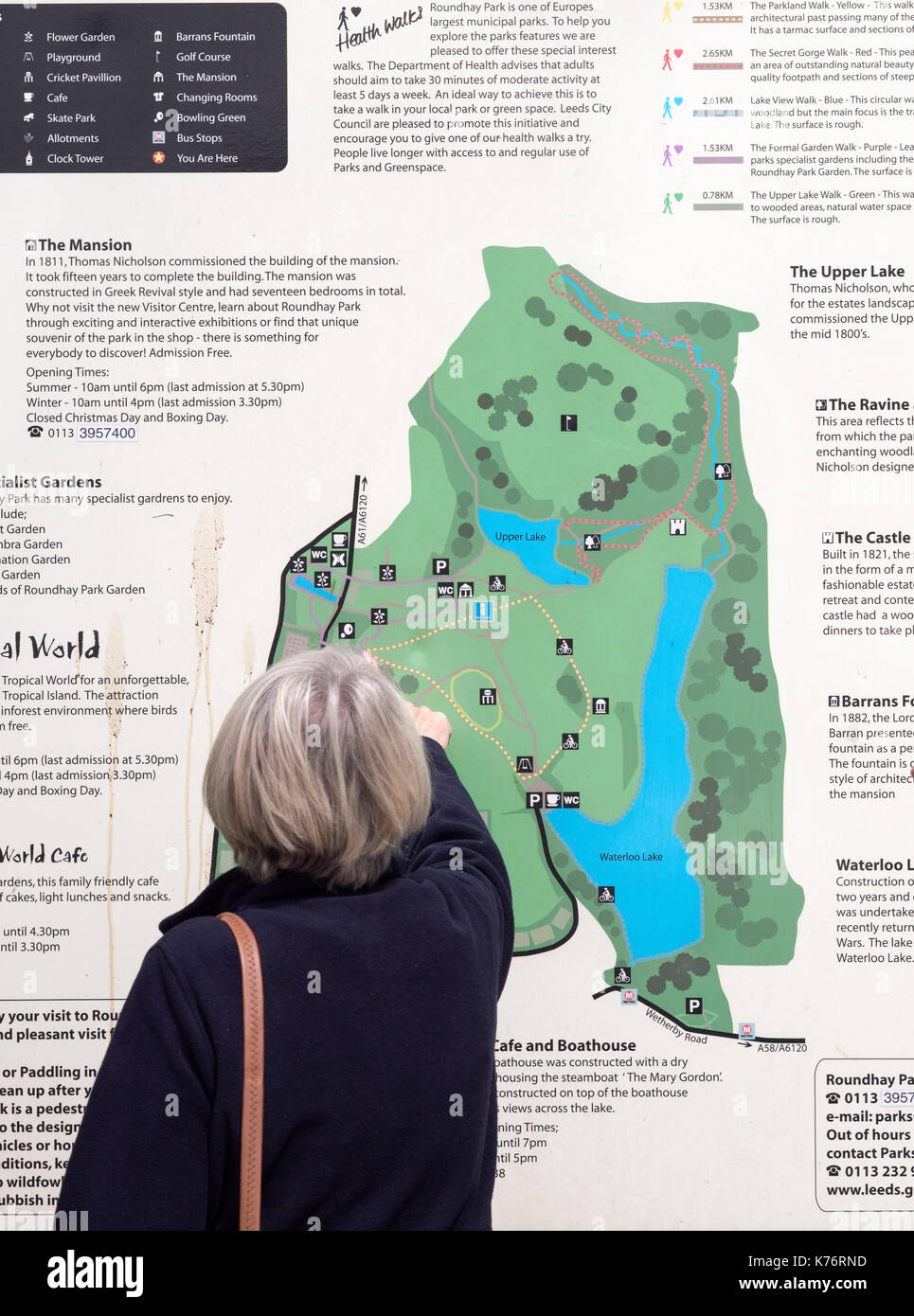 Visitor inspects visitor information board at Roundhay Park, Leeds ... Visitor inspects visitor information board at Roundhay Park, Leeds ...