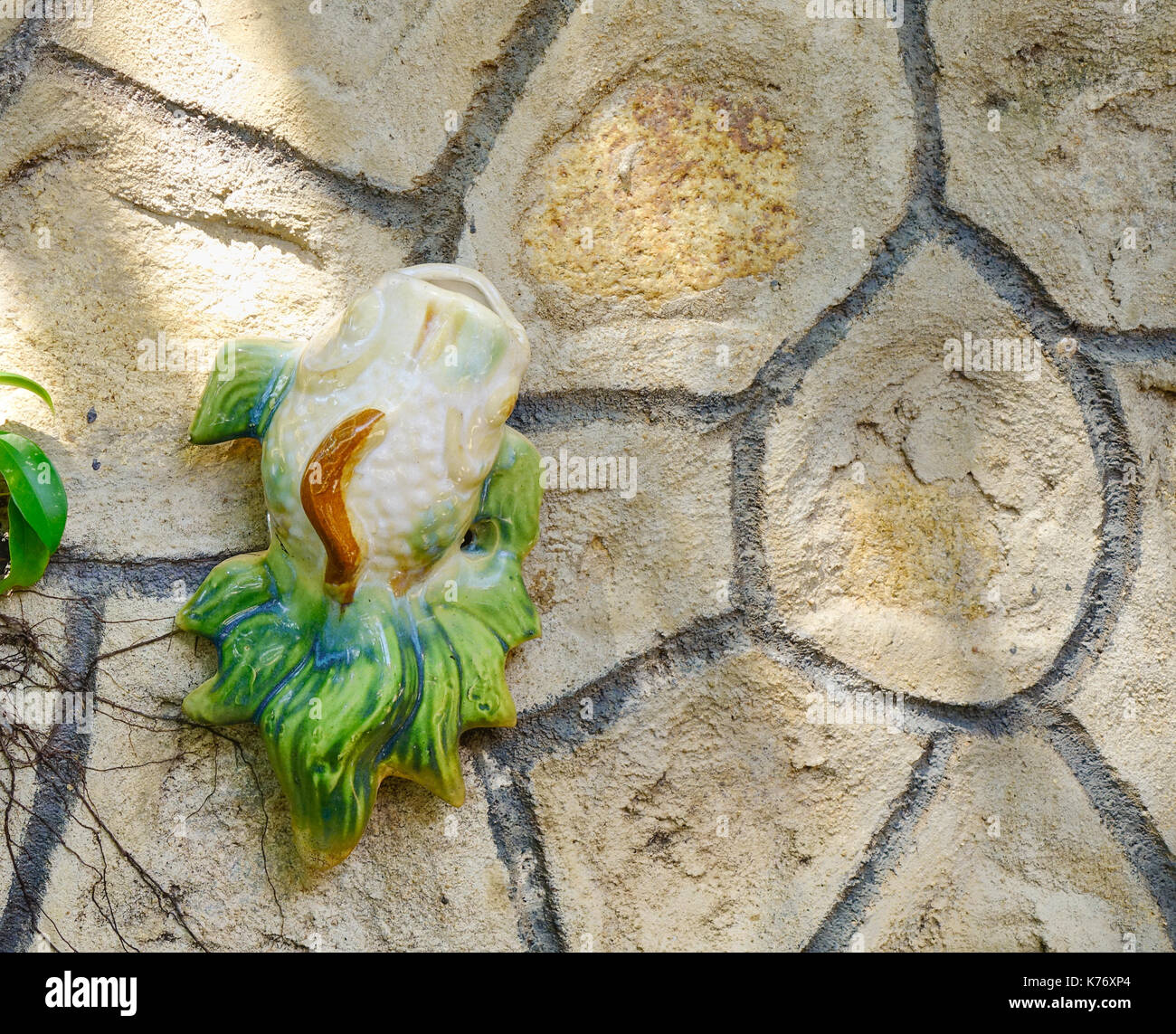 Fish statue on the stone wall surface with cement Stock Photo - Alamy