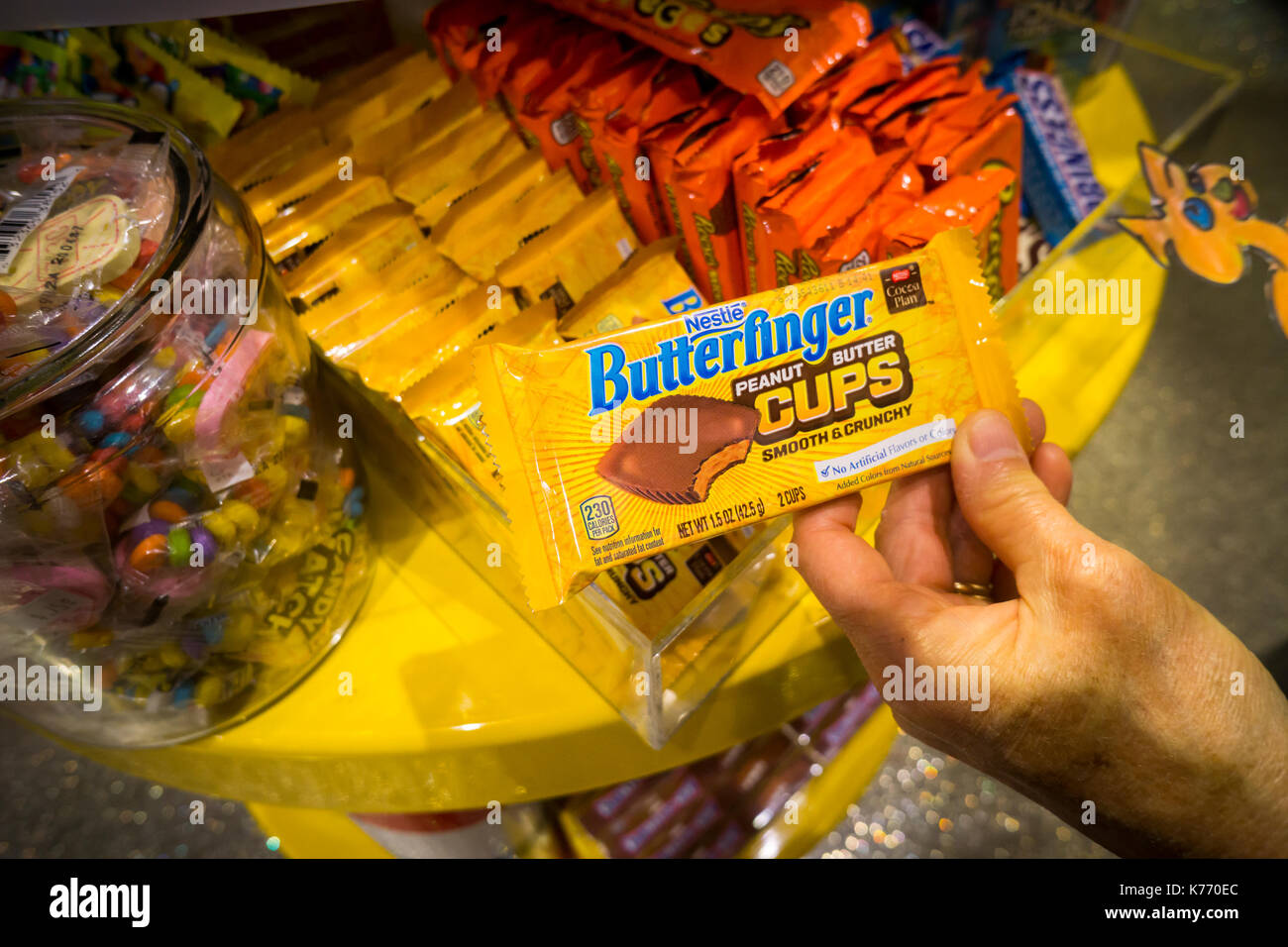 A shopper chooses a Nestlé's brand Butterfinger candy in a store in New ...