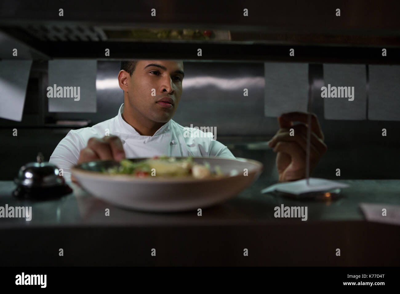 Chef looking at an order list in the commercial kitchen at restaurant ...