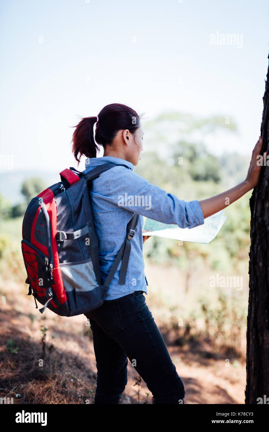 Hiking young woman with backpack watching trekking map, Hiking concept ...