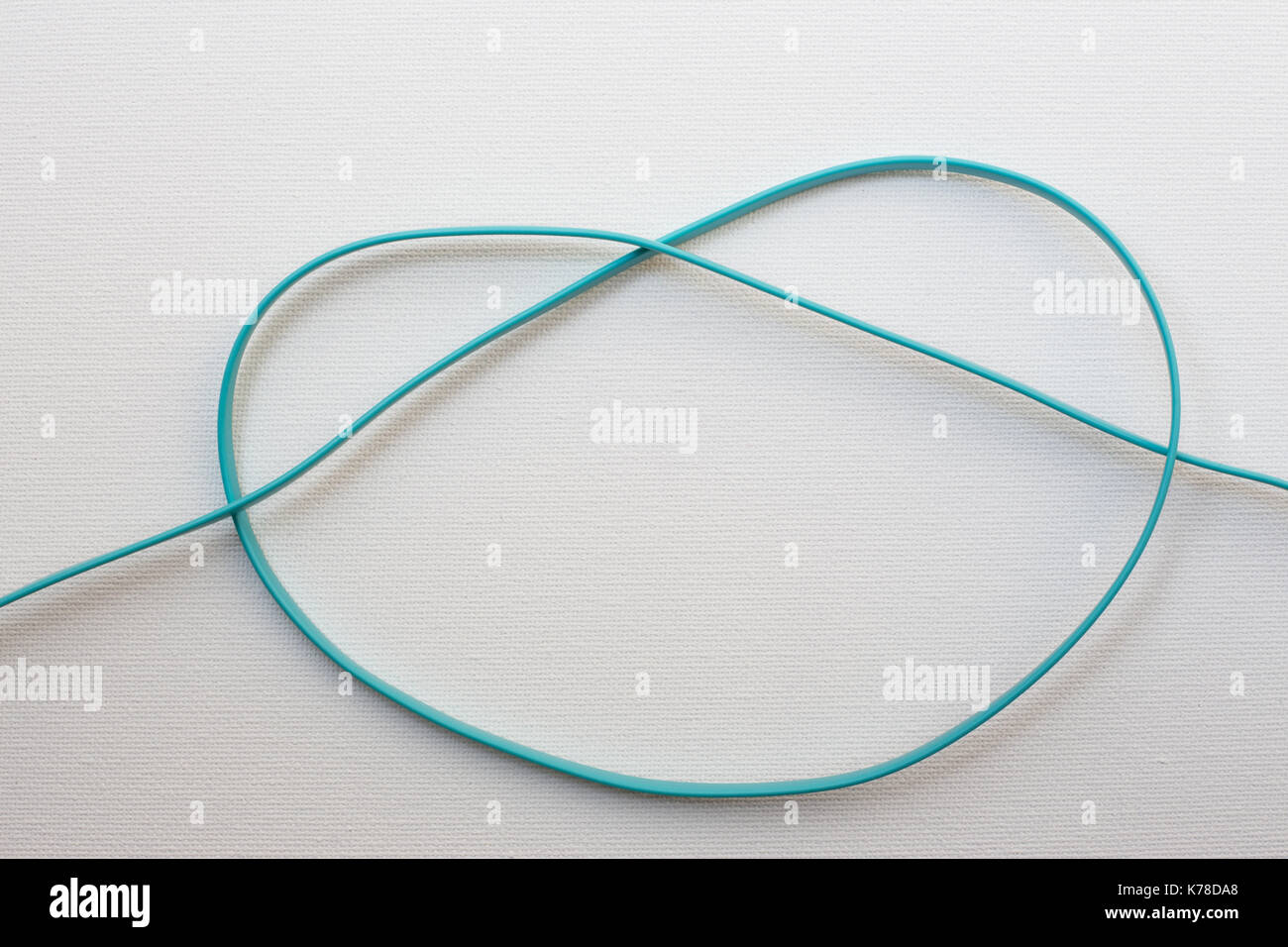 Heart-shaped tie of electric wire on white canvas background Stock ...