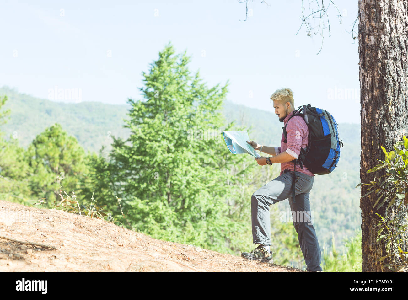 Young man reading map in forest Vintage style Stock Photo - Alamy