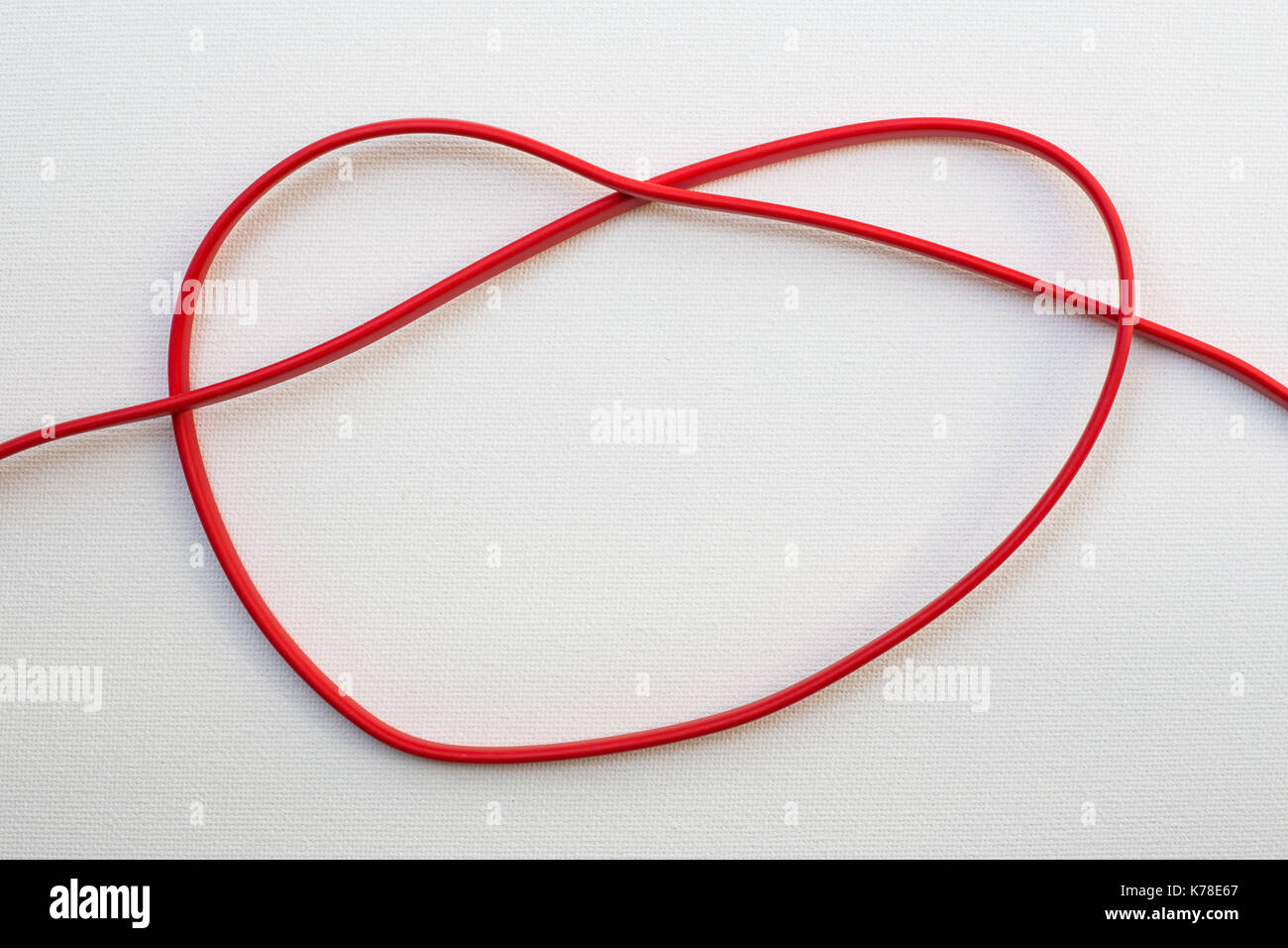 Heart-shaped tie of electric wire on white canvas background Stock ...