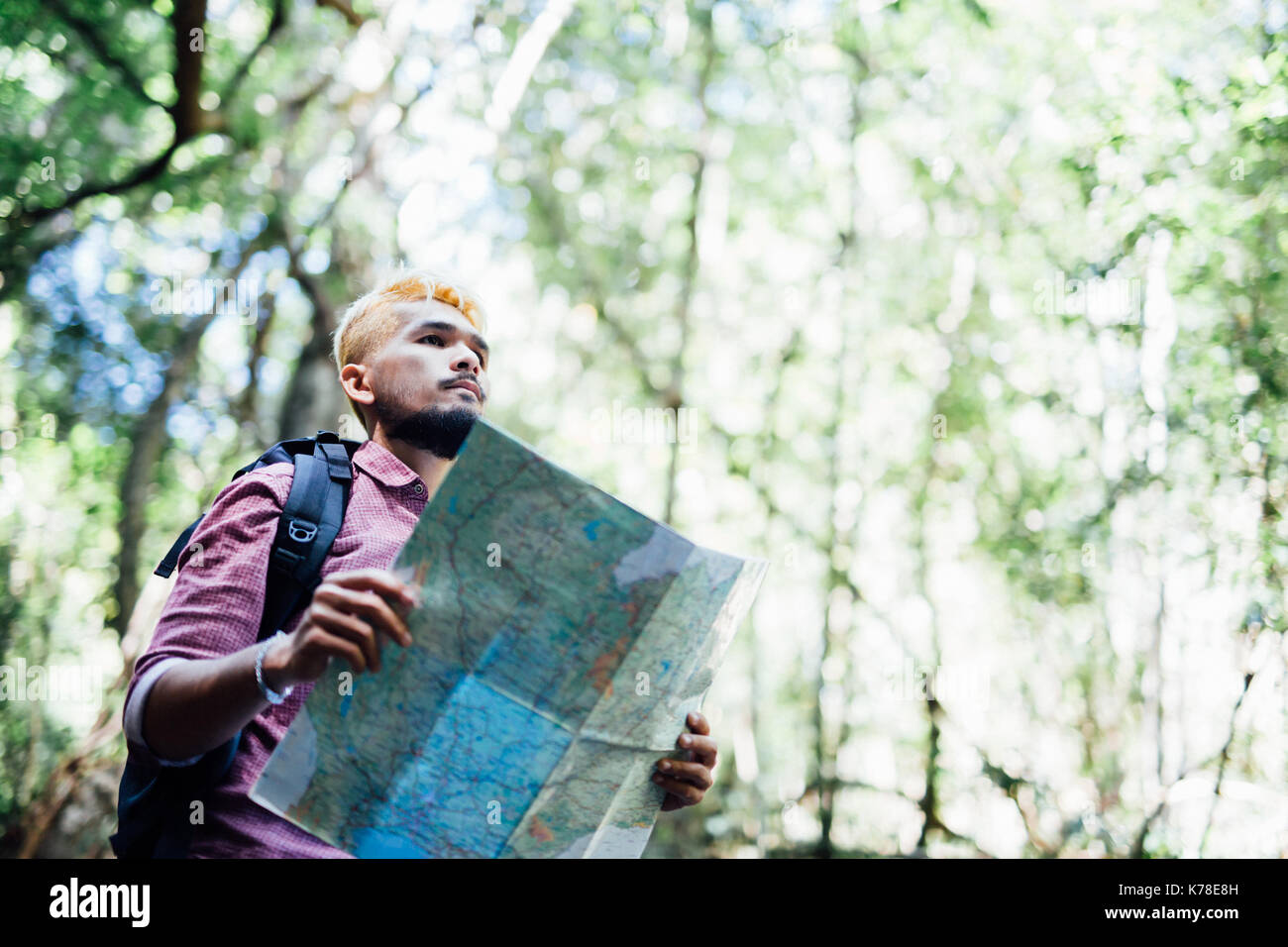 Young man reading map in forest Vintage style Stock Photo - Alamy