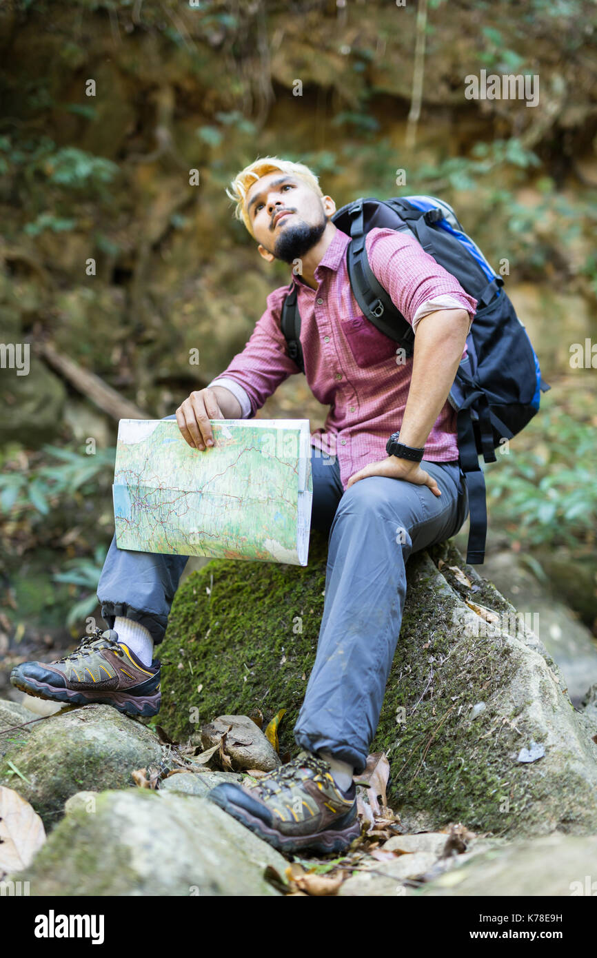 Young man reading map in forest Vintage style Stock Photo - Alamy