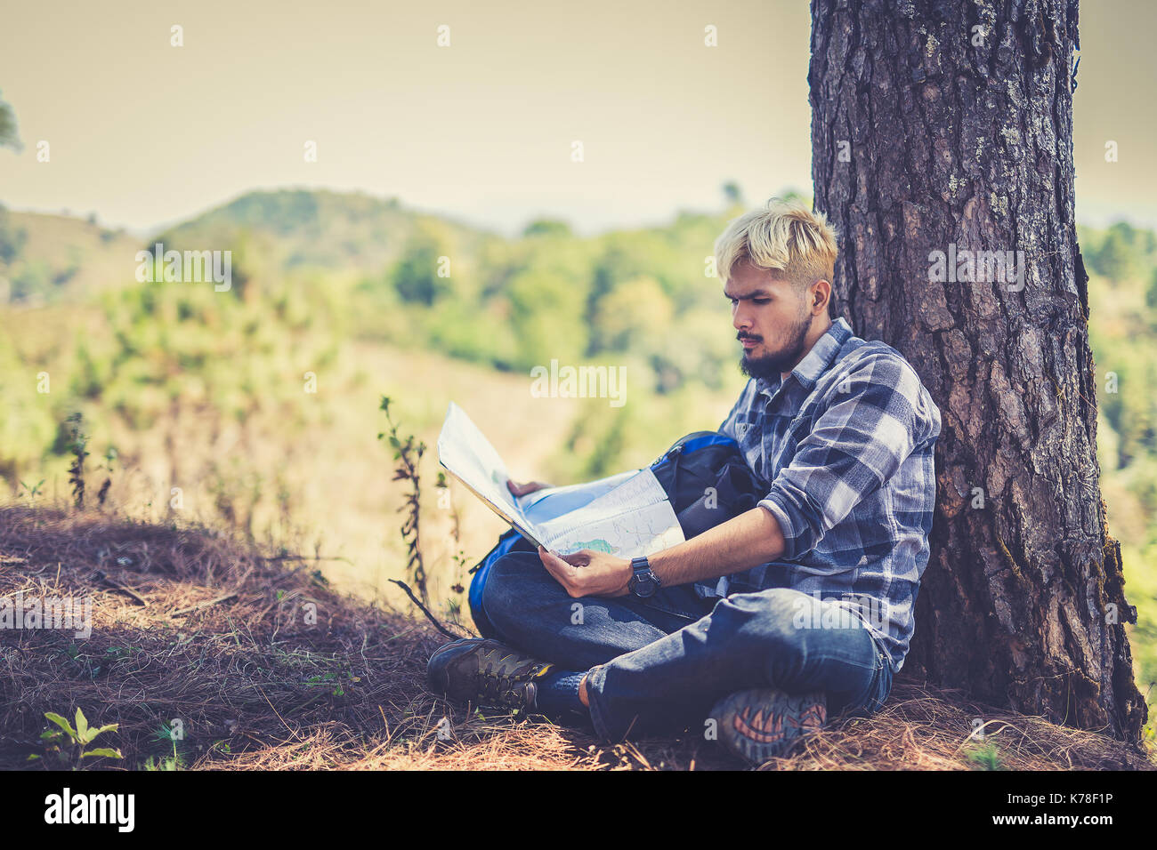 Young man reading map in forest Vintage style Stock Photo - Alamy