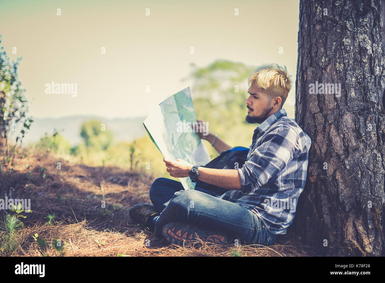 Young man reading map in forest Vintage style Stock Photo - Alamy