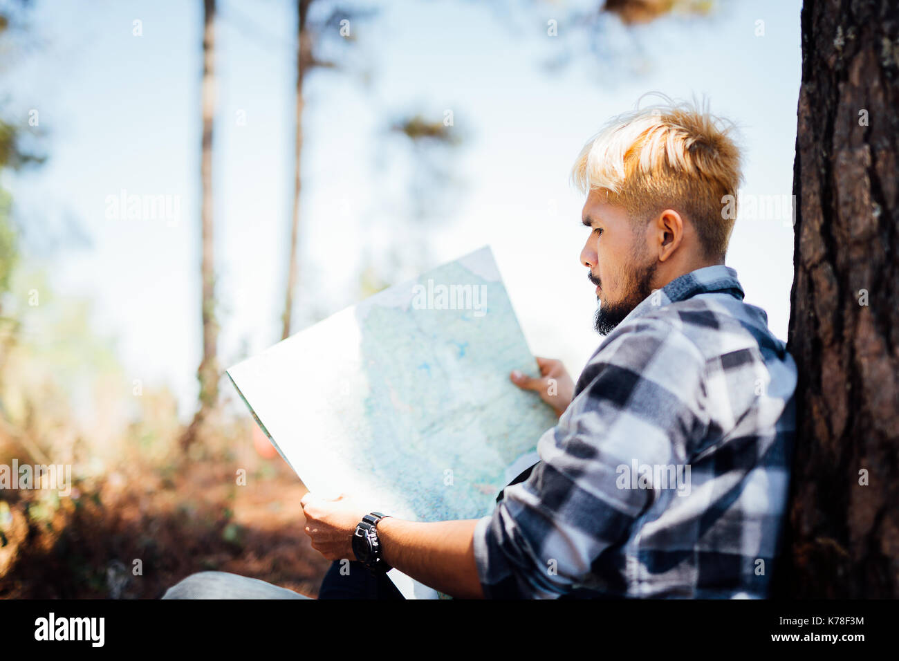 Young man reading map in forest Vintage style Stock Photo - Alamy