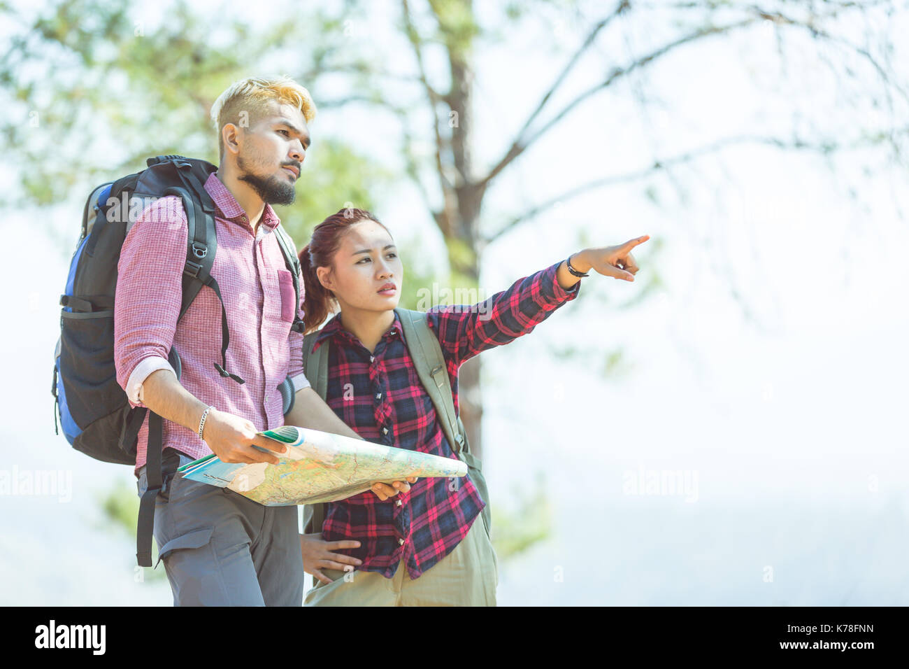 Young hiking couple reading map together in forest Vintage style Stock ...