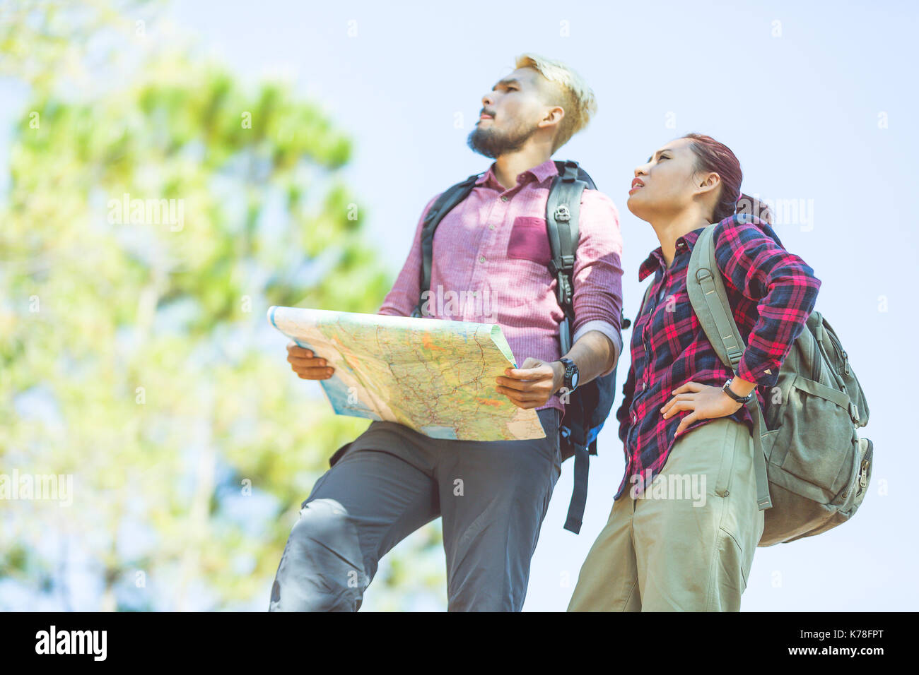 Young hiking couple reading map together in forest Vintage style Stock ...