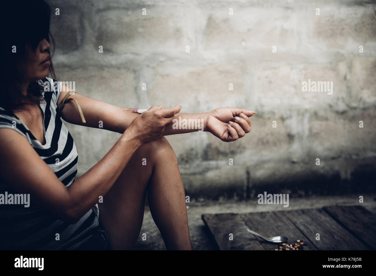 Drug addict young woman with syringe in action, Drug abuse concept ...