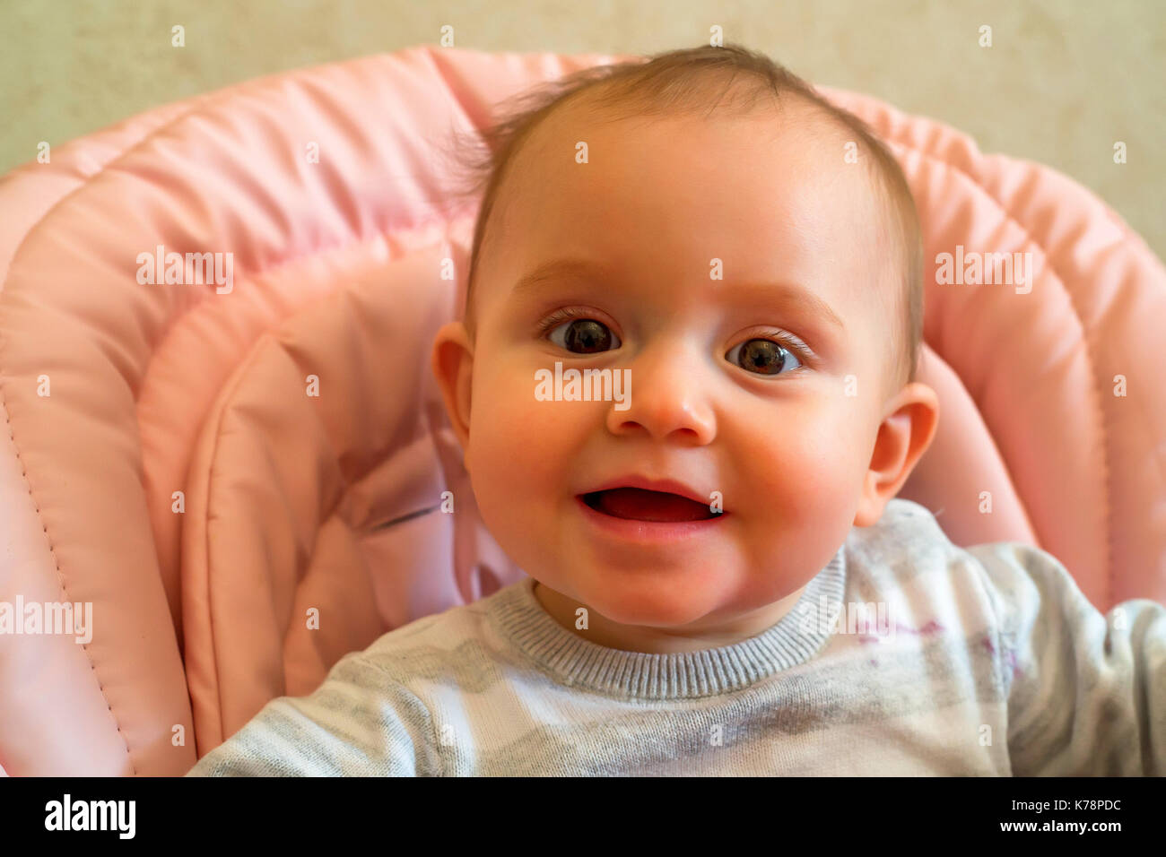 Happy baby smiling during having meal sitting in chair Stock Photo - Alamy