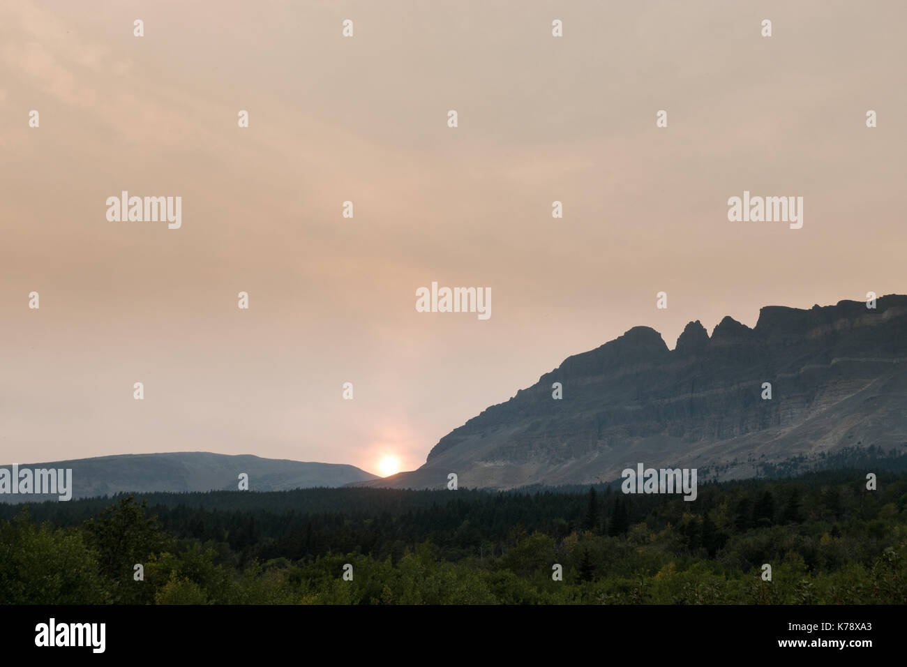 Setting sun with a smoky / hazy sky in the Glacier National Park caused ...