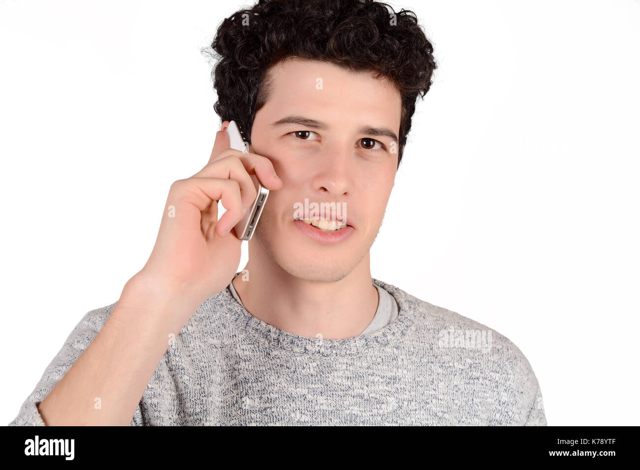 Portrait of a young handsome man talking on the phone. Isolated white ...