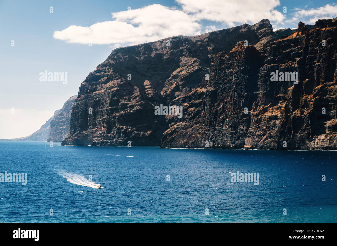 Aerial view of Los Gigantes cliffs on Tenerife. The boat sails in ocean ...