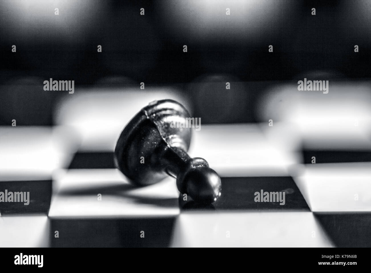 Black pawn soldier down on the chess board Stock Photo - Alamy