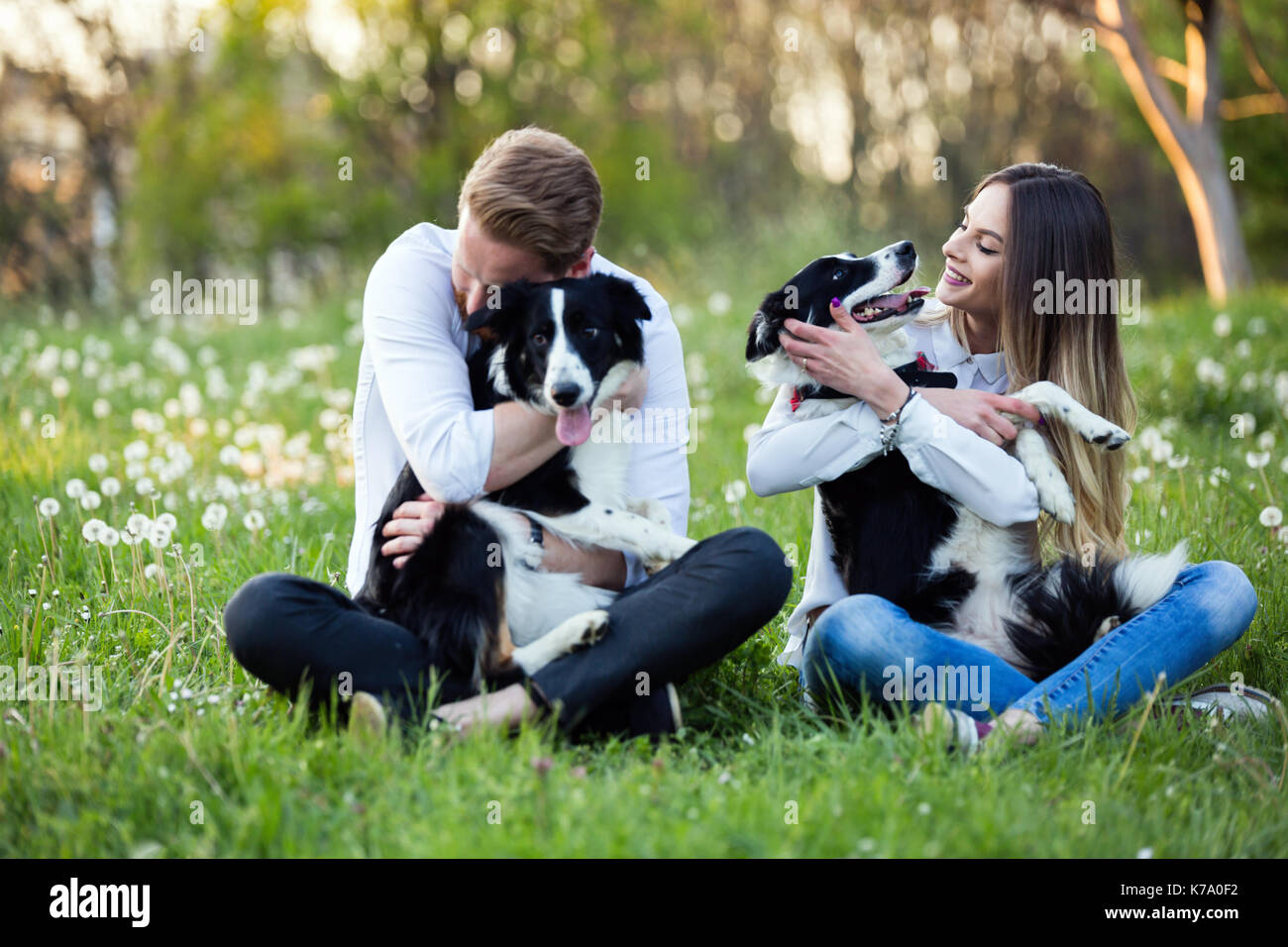 Romantic couple in love walking dogs in nature and smiling Stock Photo ...