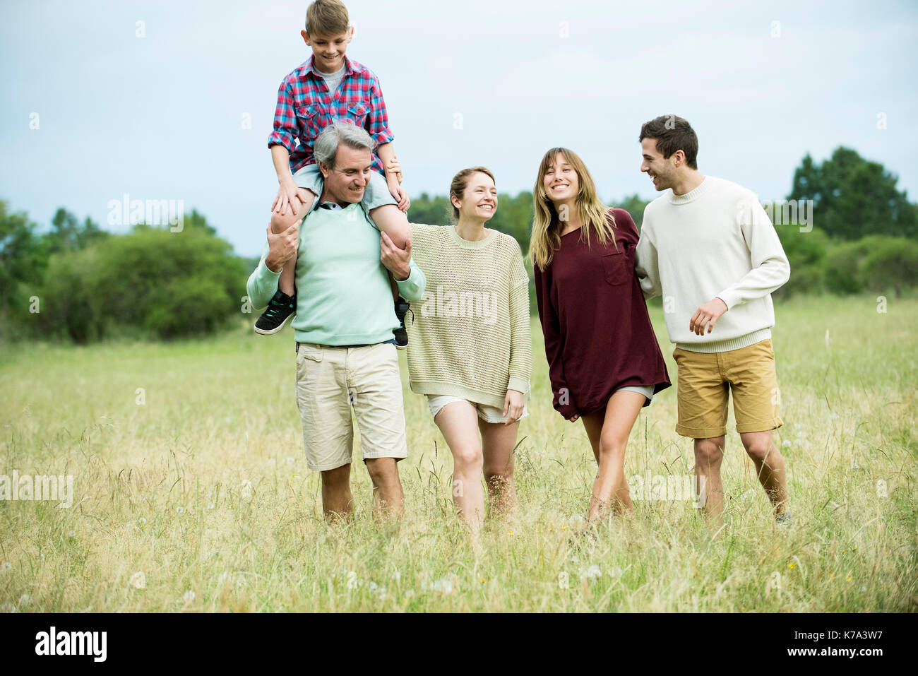 Family strolling together in meadow Stock Photo - Alamy