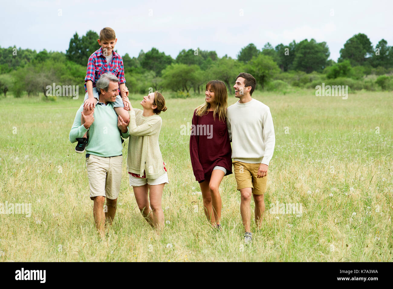 Family walking together through field Stock Photo - Alamy