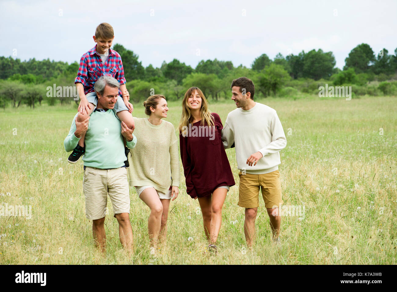 Family walking together through field Stock Photo - Alamy