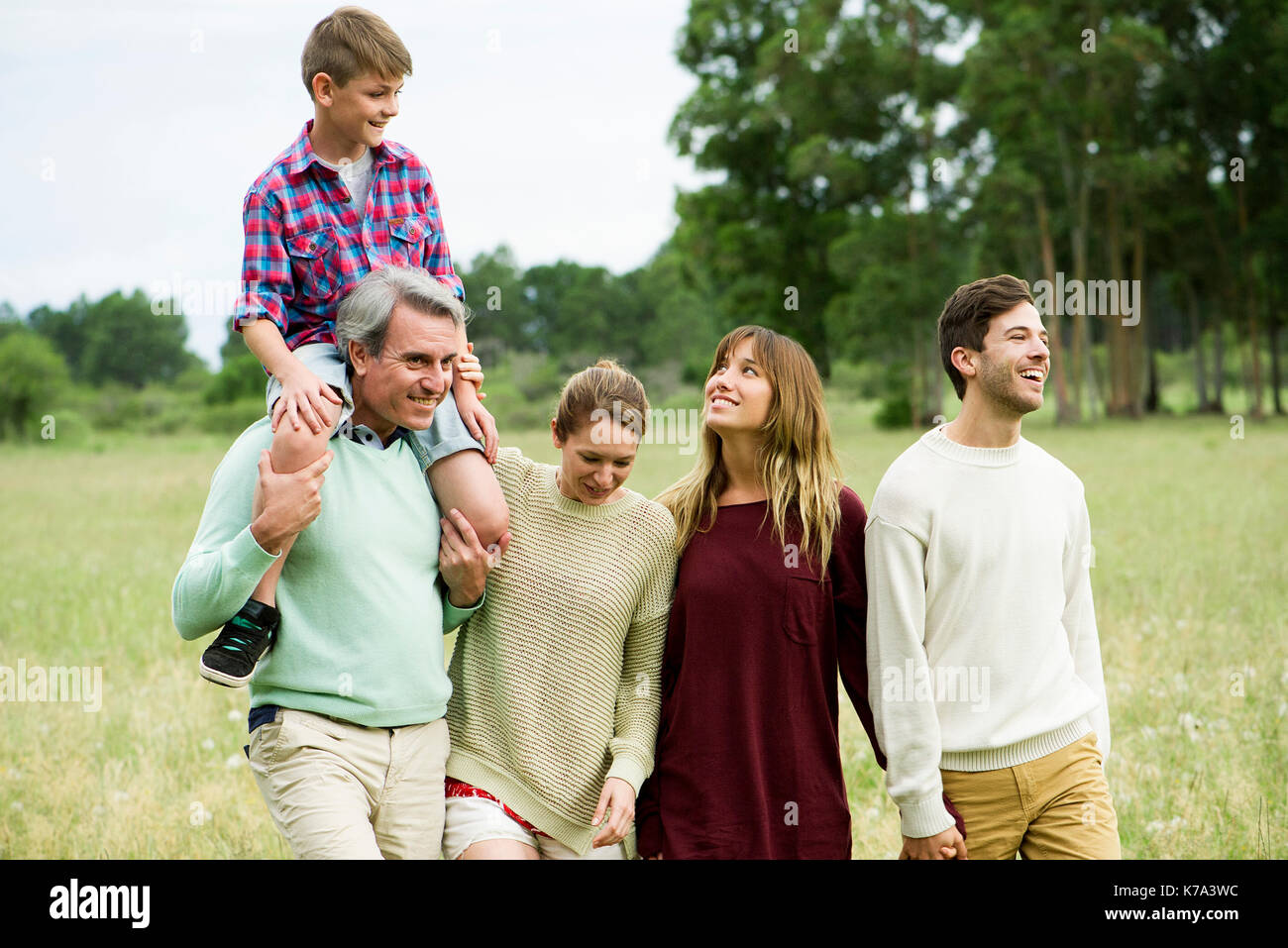 Family walking together through field Stock Photo - Alamy