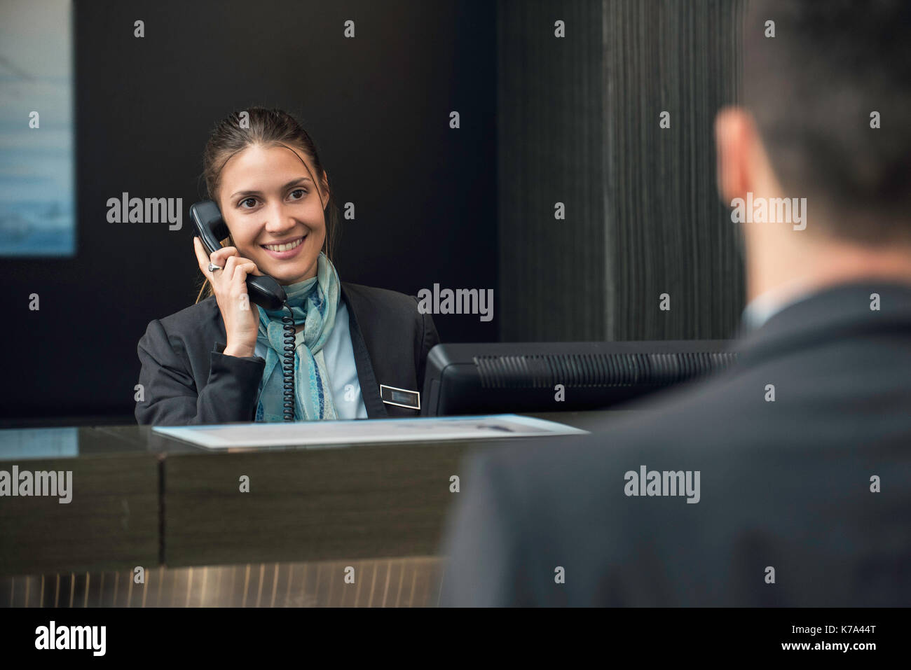 Hotel receptionist talking on phone Stock Photo - Alamy