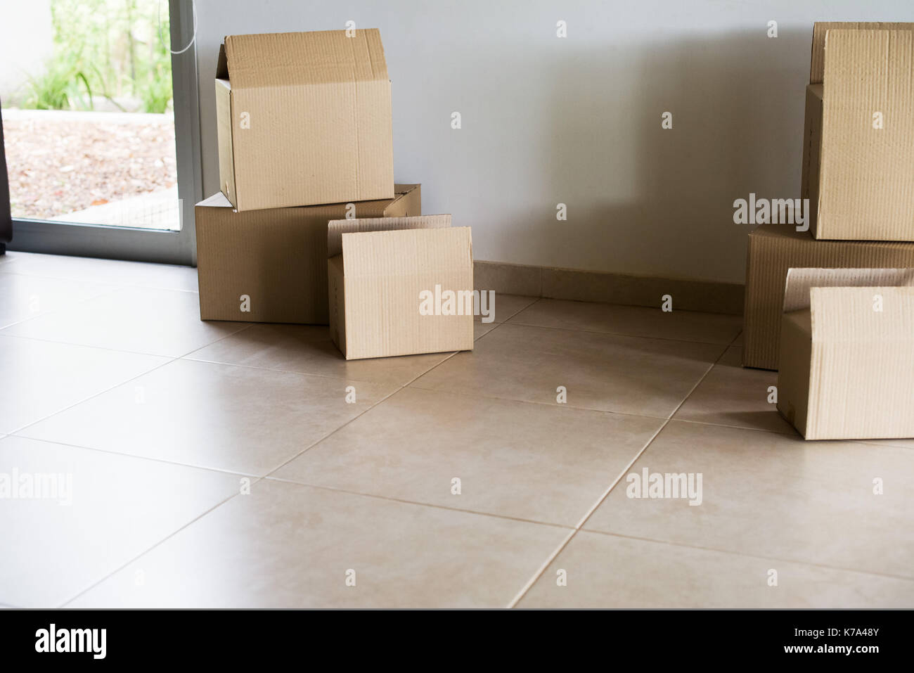 Cardboard boxes in empty living room Stock Photo - Alamy