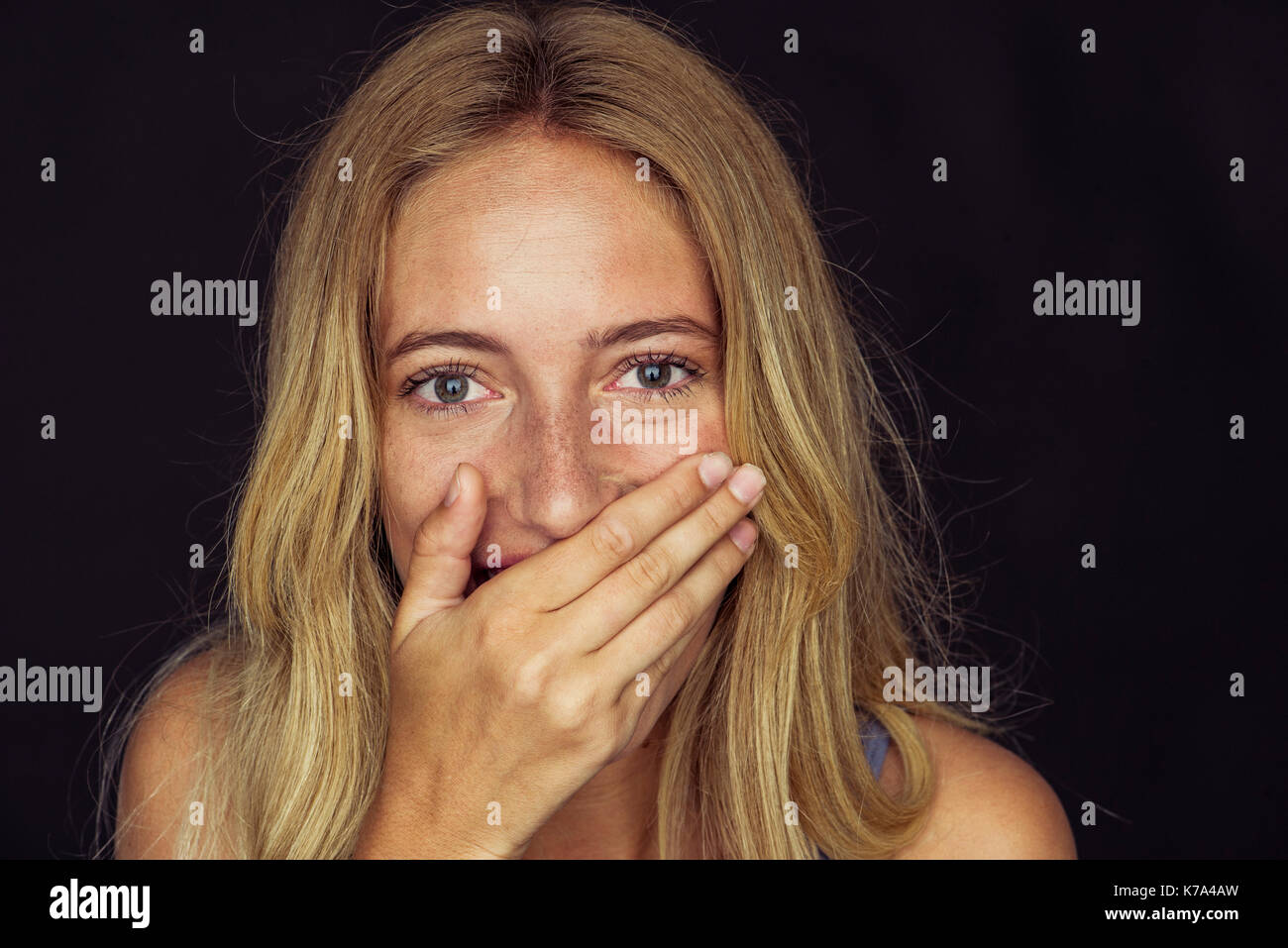 Young woman laughing with hand over mouth Stock Photo - Alamy