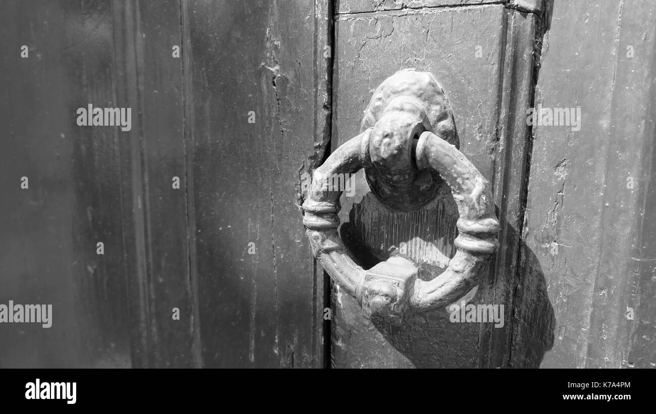 Black and white or monochrome photo of a vintage rustic metal door loop ...