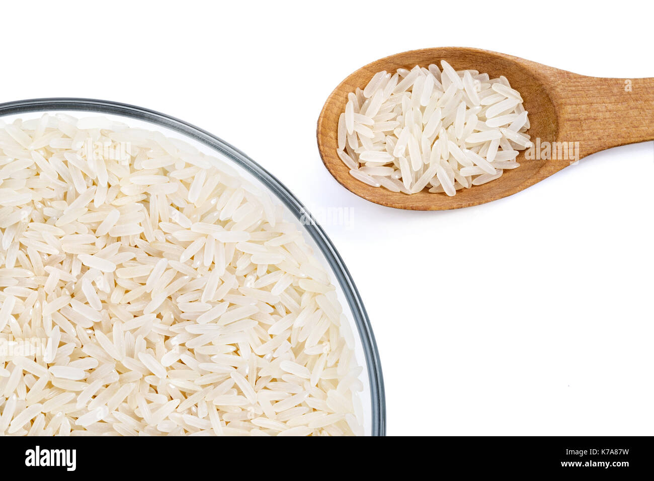 Close up of parboiled rice in glass bowl and wooden spoon on white ...