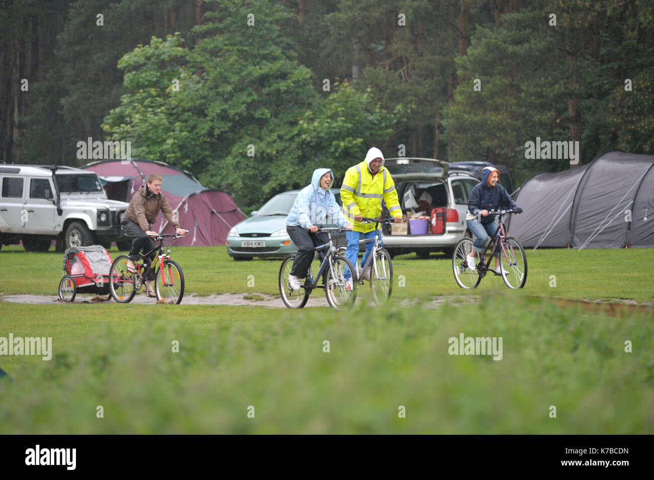 family cycling in the rain on camping holiday Stock Photo - Alamy