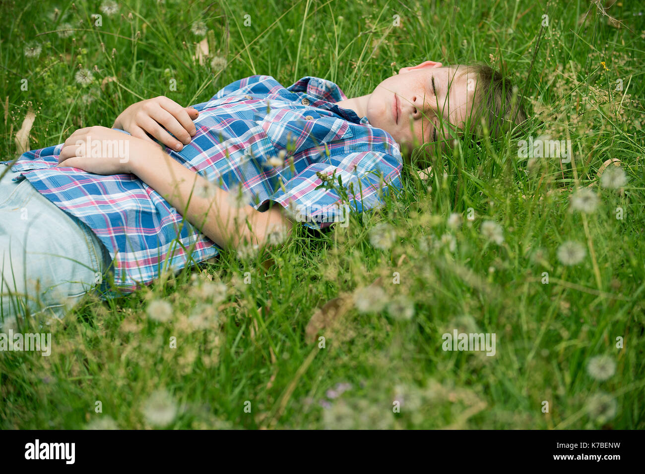 Boy napping on grass Stock Photo - Alamy