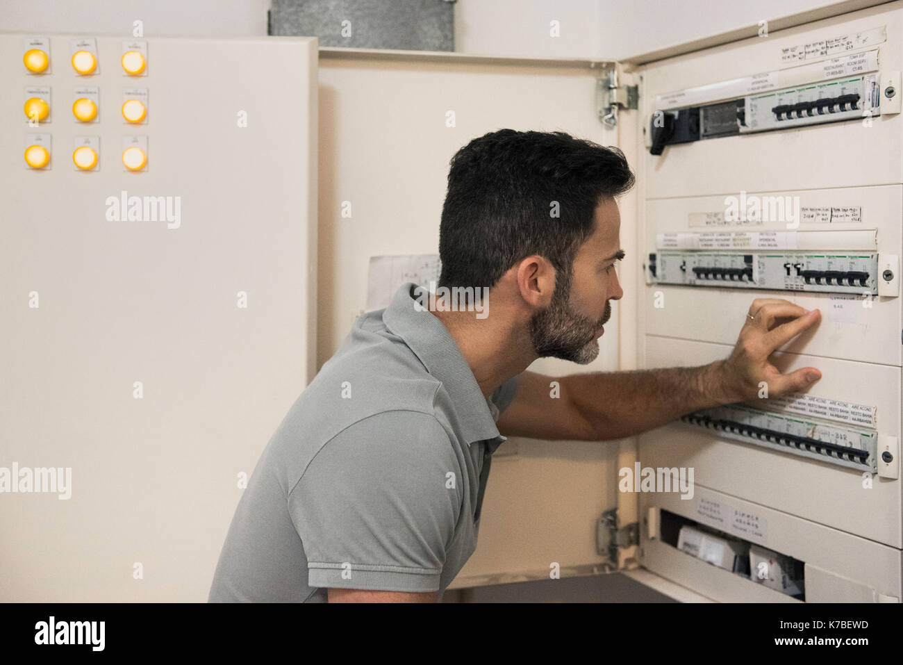 Electrician checking electric control cabinet Stock Photo - Alamy