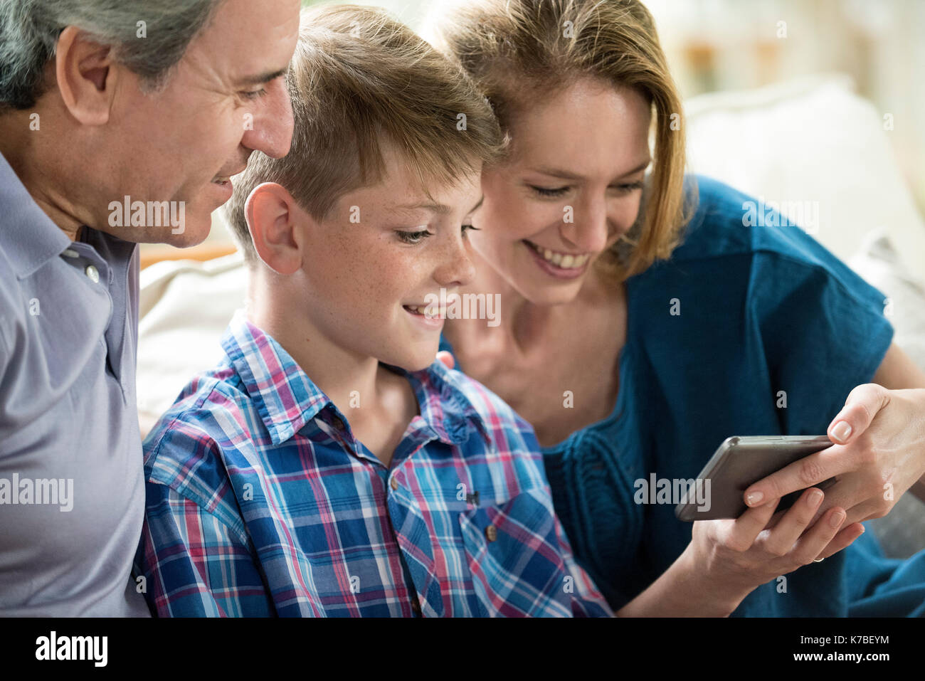 Family looking at smartphone together Stock Photo - Alamy