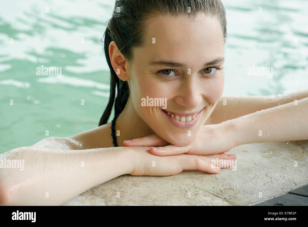 Woman in swimming pool at edge resting head on arms Stock Photo - Alamy