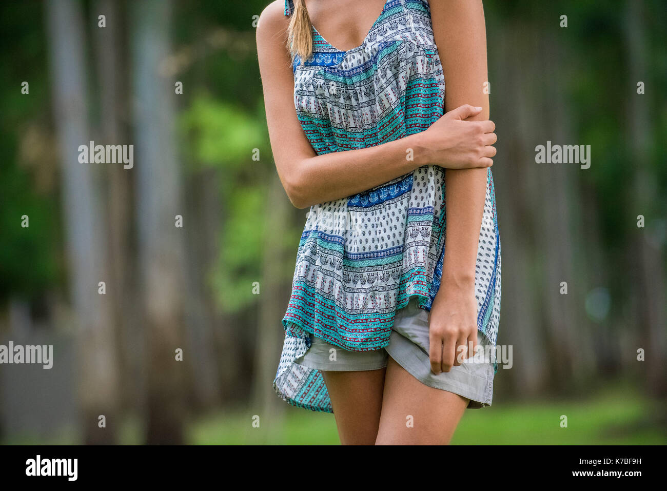 Young woman standing with arm folded across stomach, cropped Stock ...