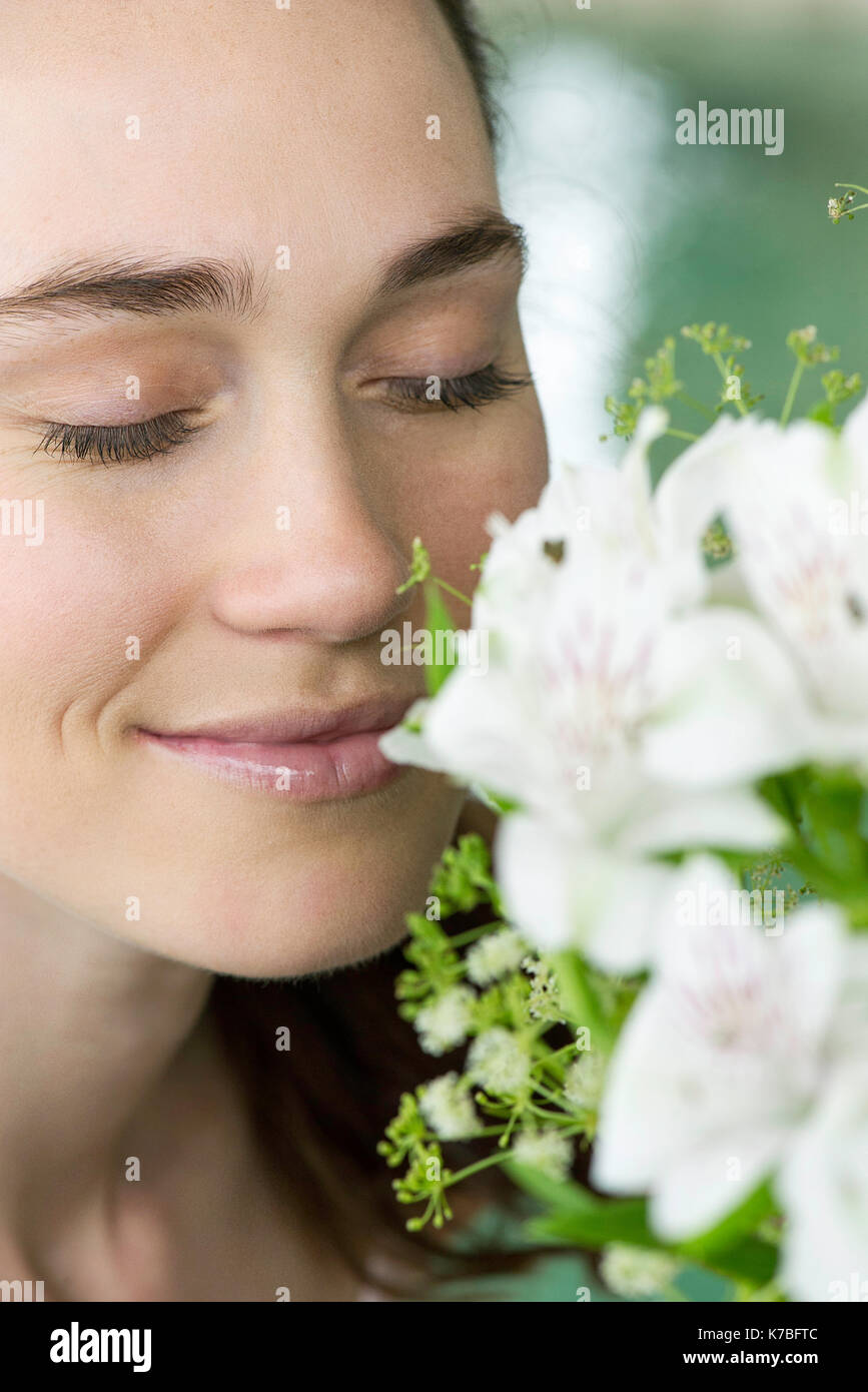 Young woman smelling bouquet of fresh flowers Stock Photo - Alamy