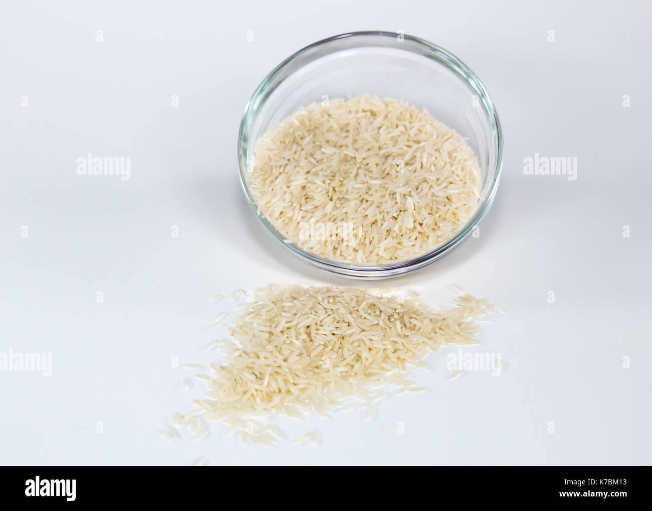 Basmati rice spilling from glass bowl Stock Photo - Alamy