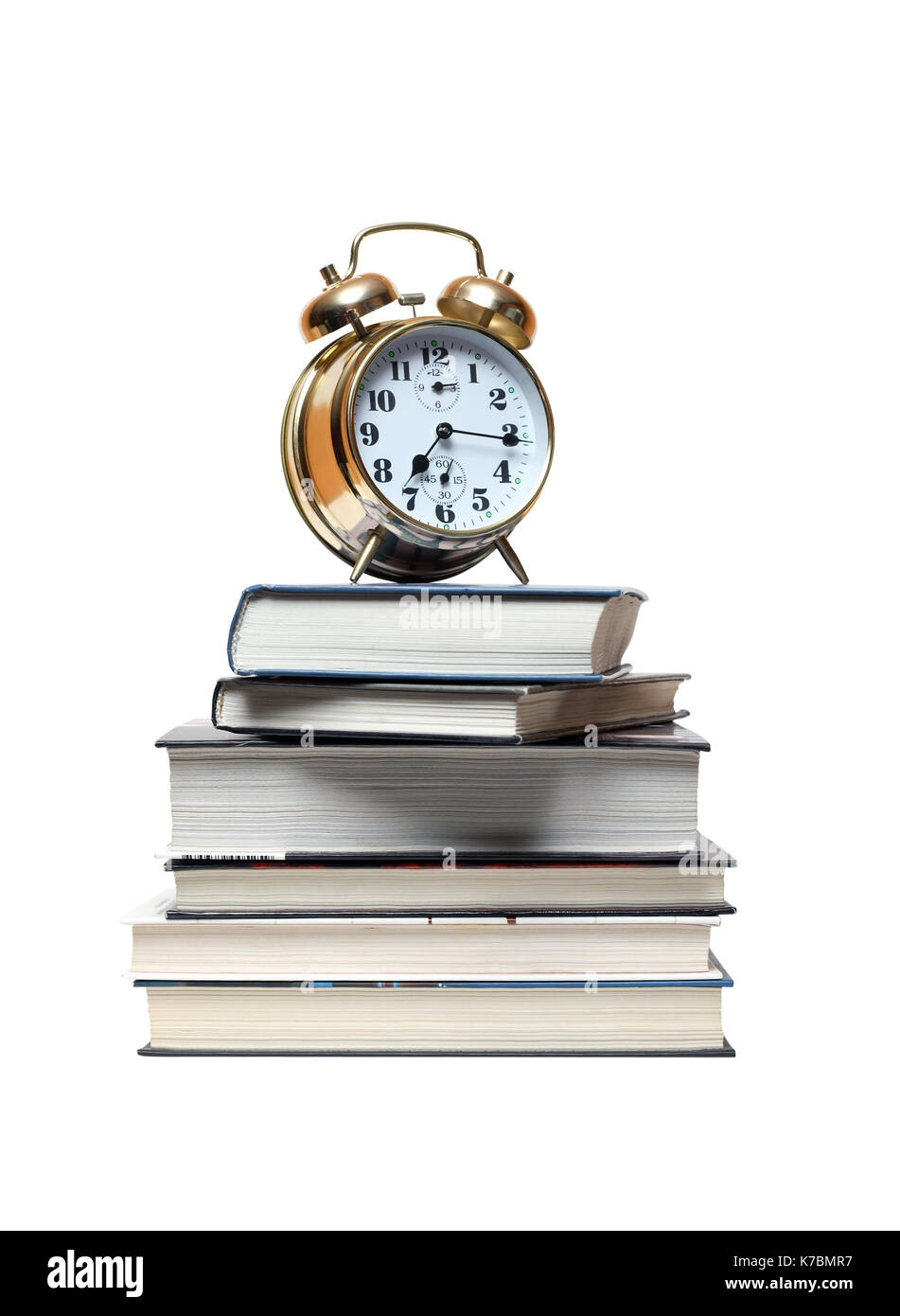 Alarm clock standing on stack of books. Isolated on white with clipping ...
