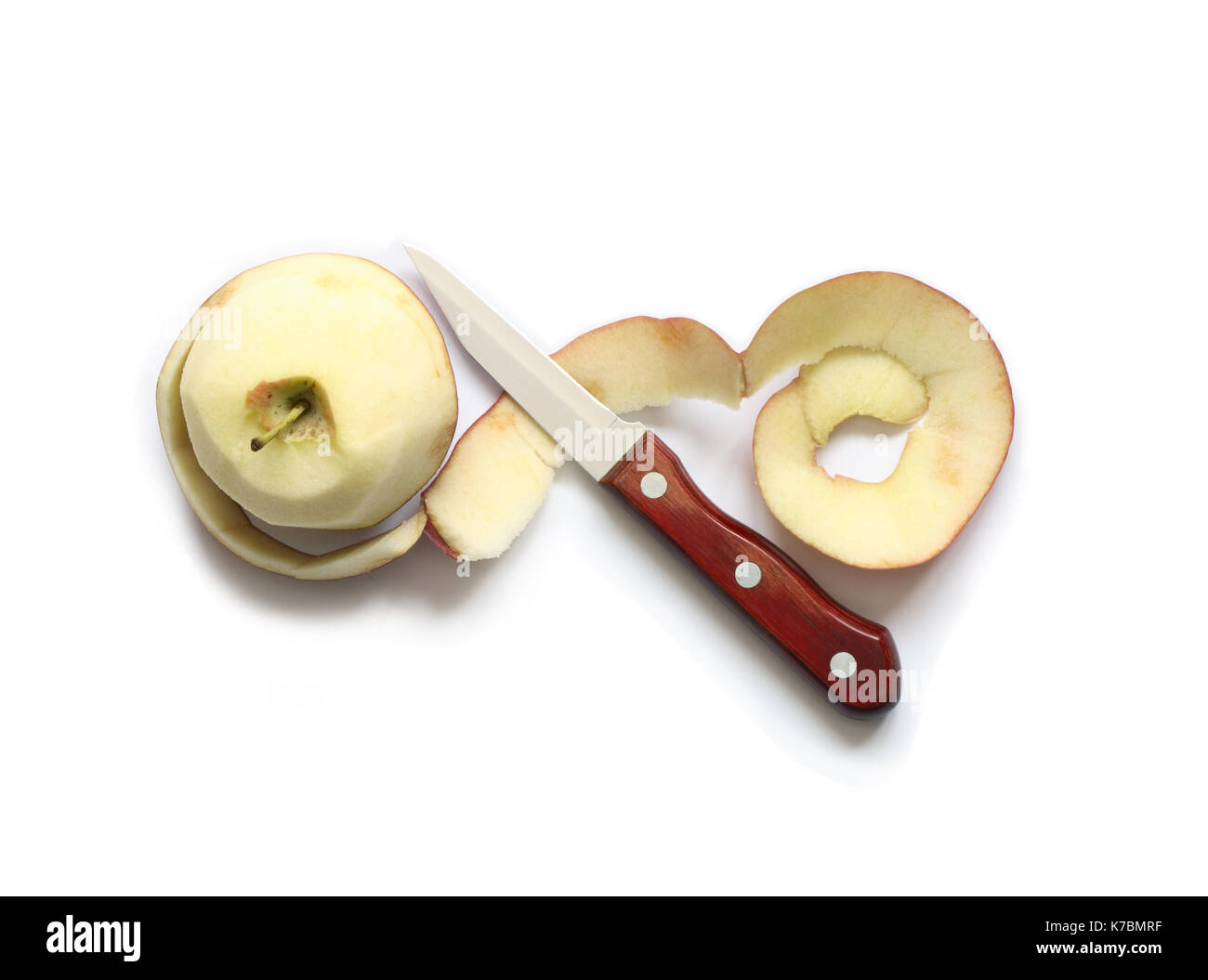 Apple peeled with twisting skin and knife lying on white background ...