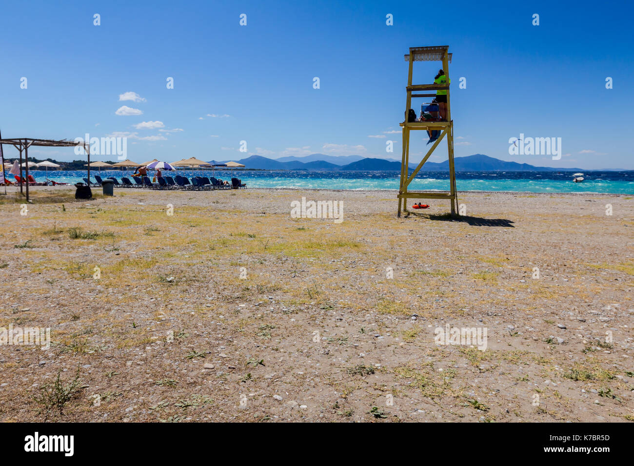 Lifeguard post at sandy public beach with umbrellas and loungers next ...