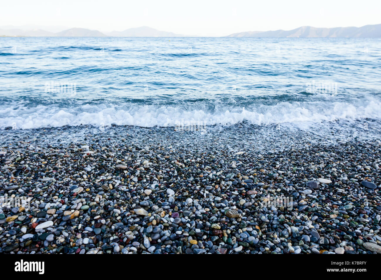 View on the small waves at coastline, sea with foamy waves on early ...