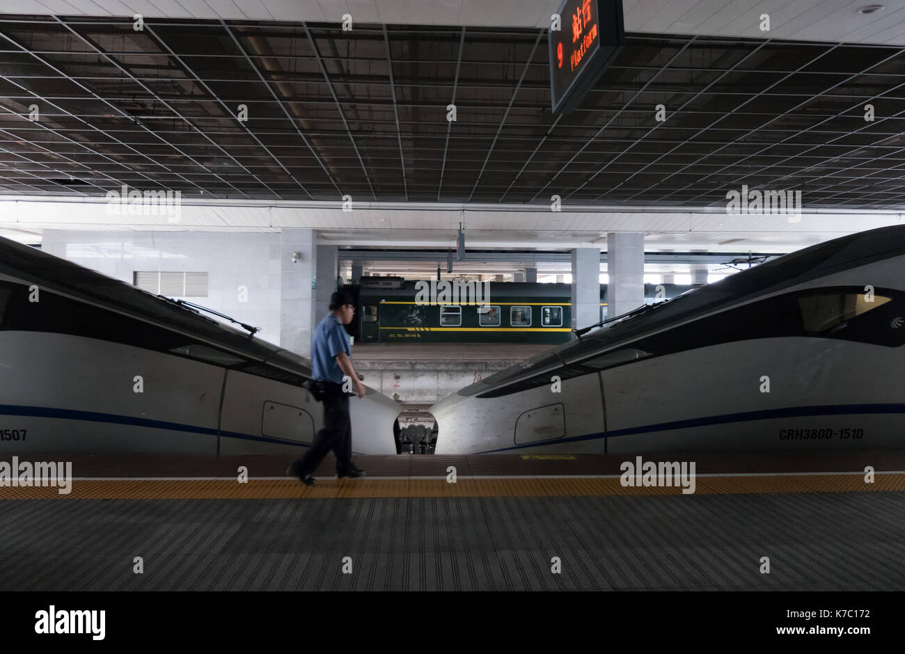 Chinese worker doing maintenance check on bullet train in Shanghai ...