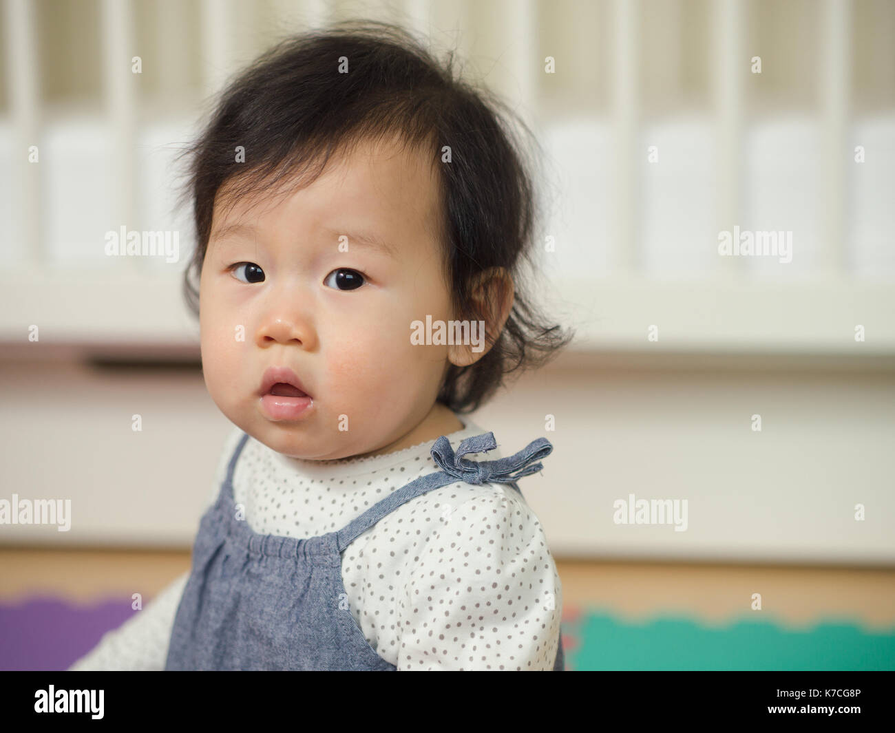 Baby girl with serious face Stock Photo - Alamy