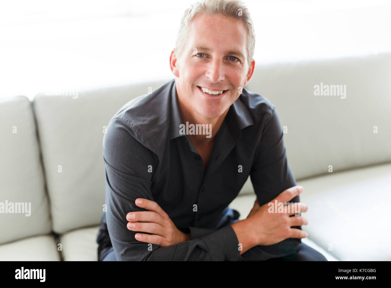 Portrait of single 40s man sitting in sofa Stock Photo - Alamy
